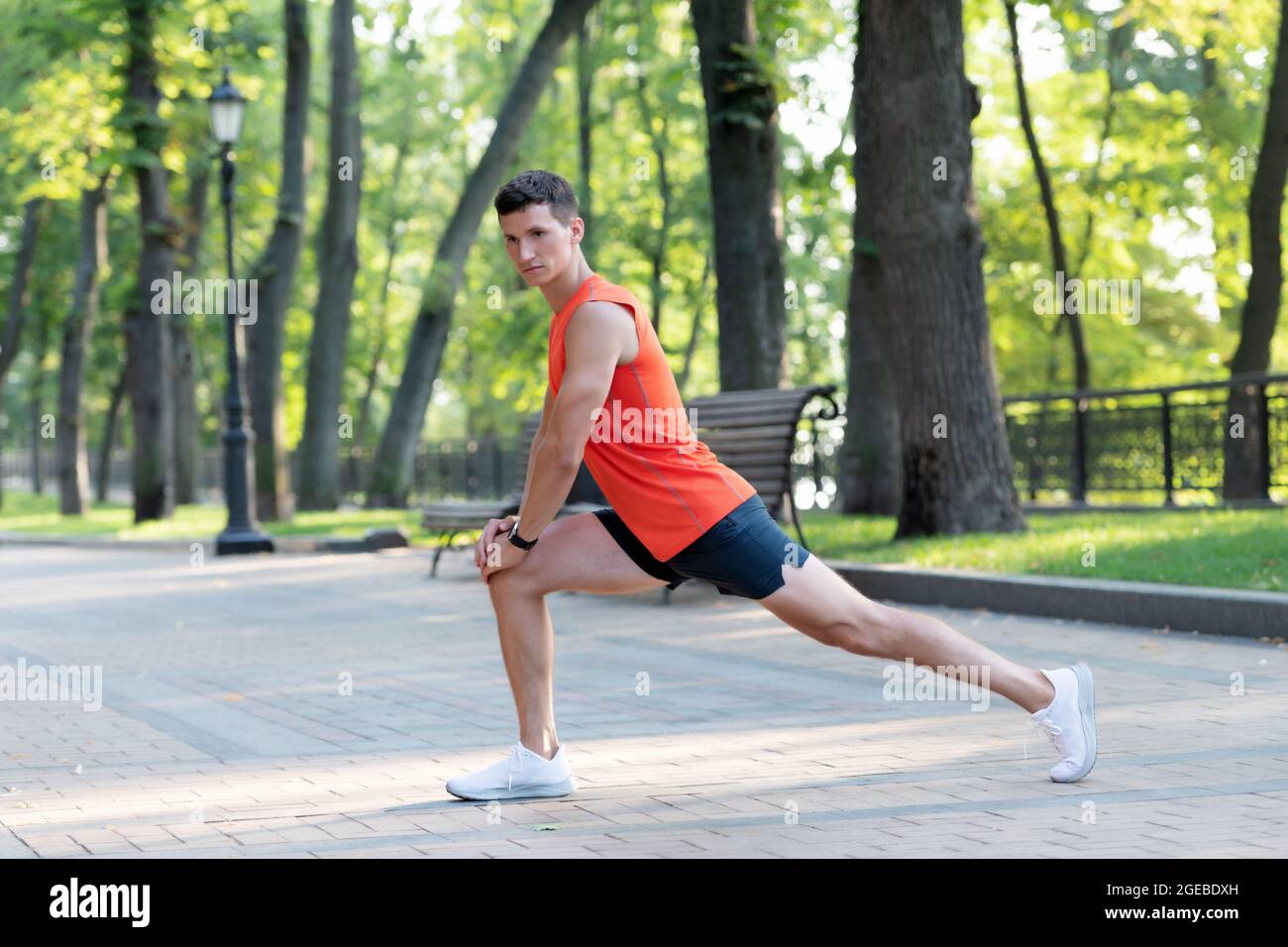 Warming up before workout. Fit guy hold lunge position. Man do warm-up exercises. Warm-up ...