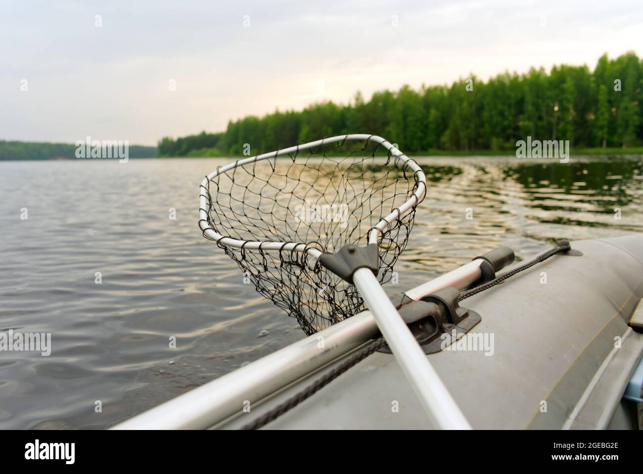fishing on an inflatable boat. A paddle and a landing net on board ...