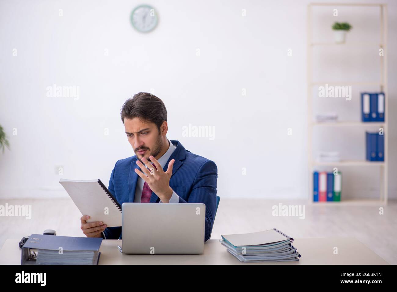 Young businessman employee reading paper at workplace Stock Photo - Alamy