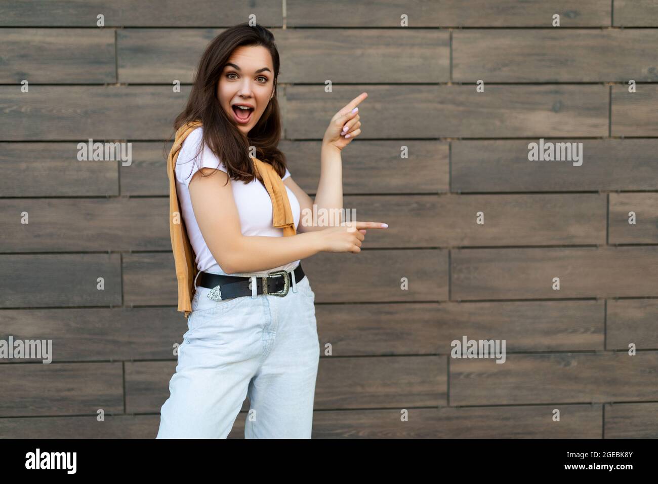 Portrait of beautiful fascinating emotional female promoter pointing to ...