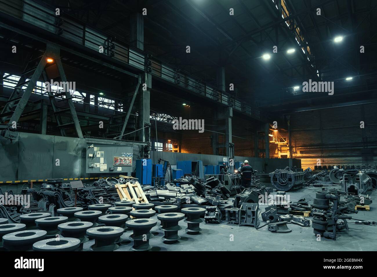 Metallurgical factory workshop interior with working welder and metal ...
