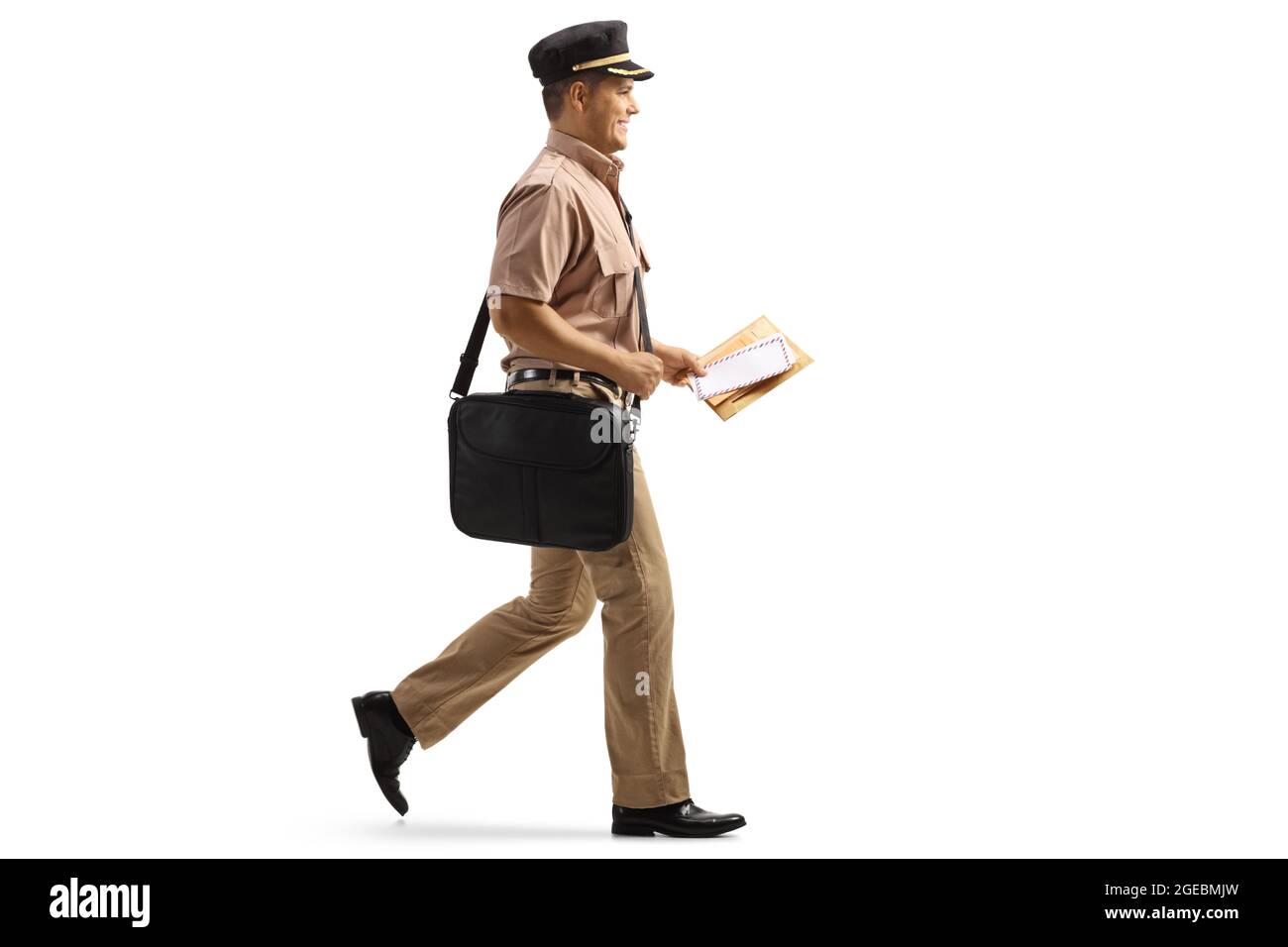 Full length profile shot of a mailman walking and carrying letters and ...