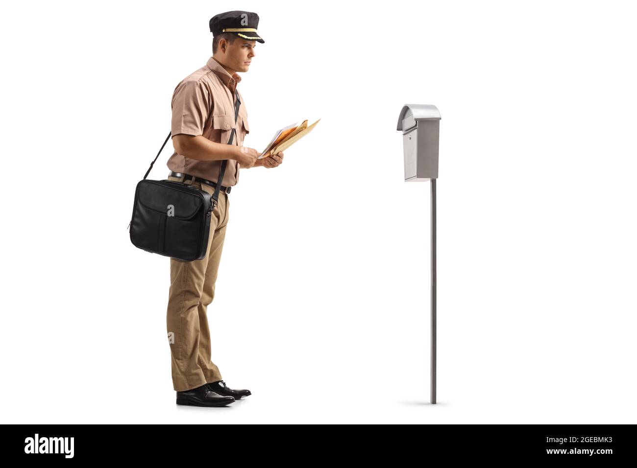 Full length profile shot of a mailman putting a letter in a mailbox ...