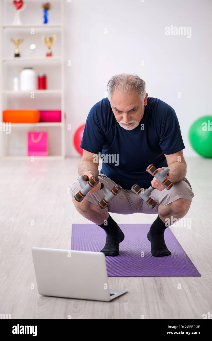 Old man doing sport exercises at home Stock Photo - Alamy