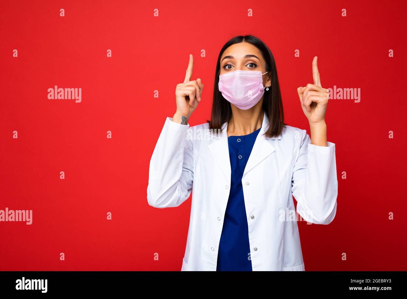 Young beautiful brunette woman in virus protective mask on face against ...