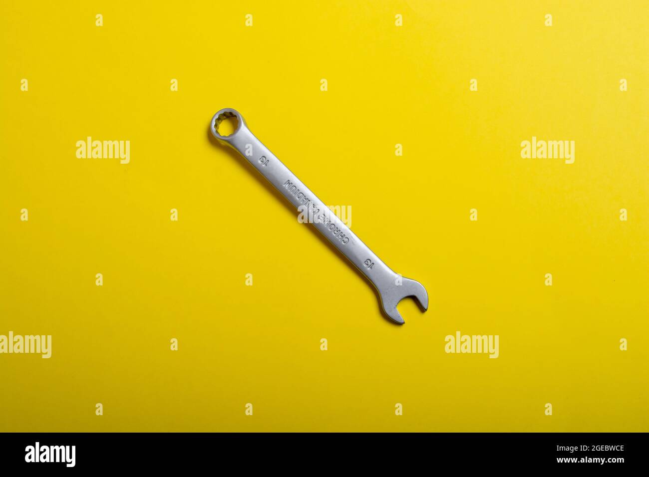 wrench on a yellow background Stock Photo - Alamy