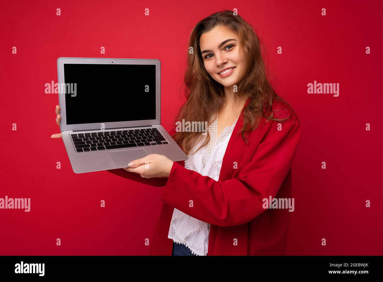 Photo of Beautiful smiling happy young brunette woman holding computer ...