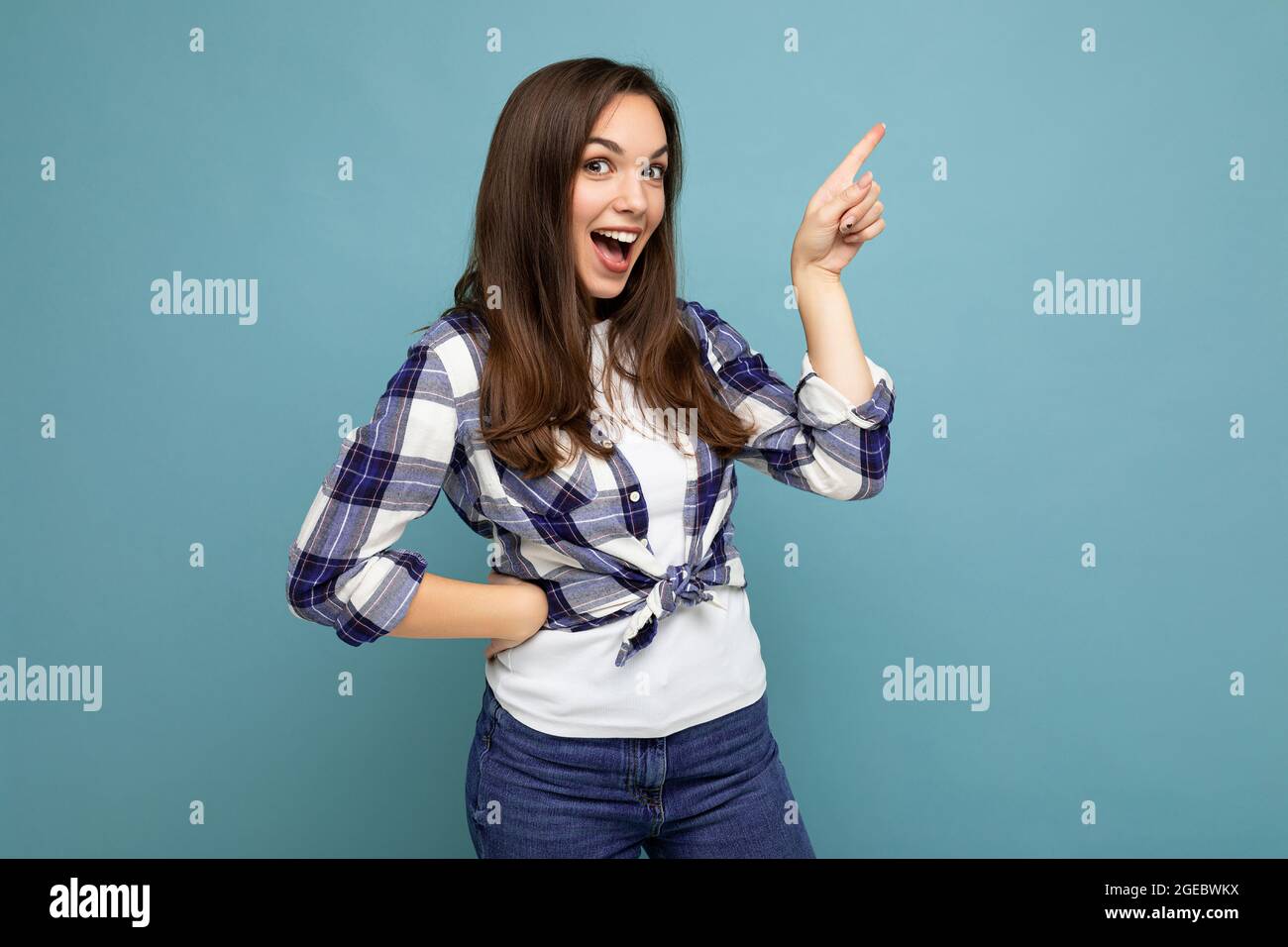 Portrait of beautiful fascinating female promoter pointing to the side ...
