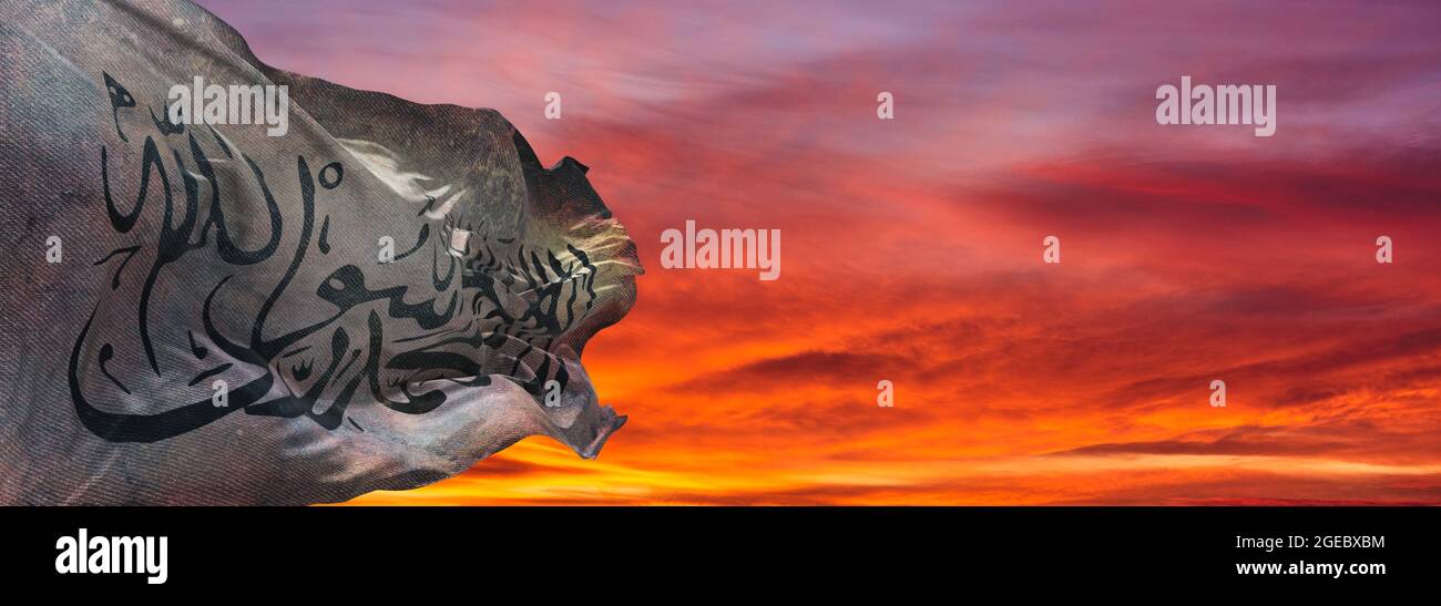 retro old white Taliban flag waving at cloudy sky background on sunset ...