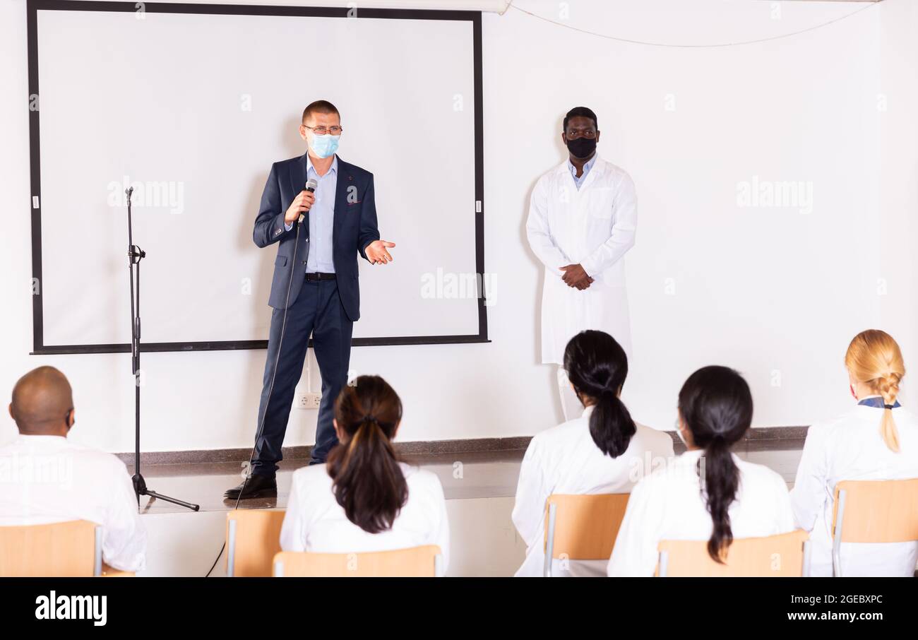 Male coach giving speech at conference hall Stock Photo - Alamy
