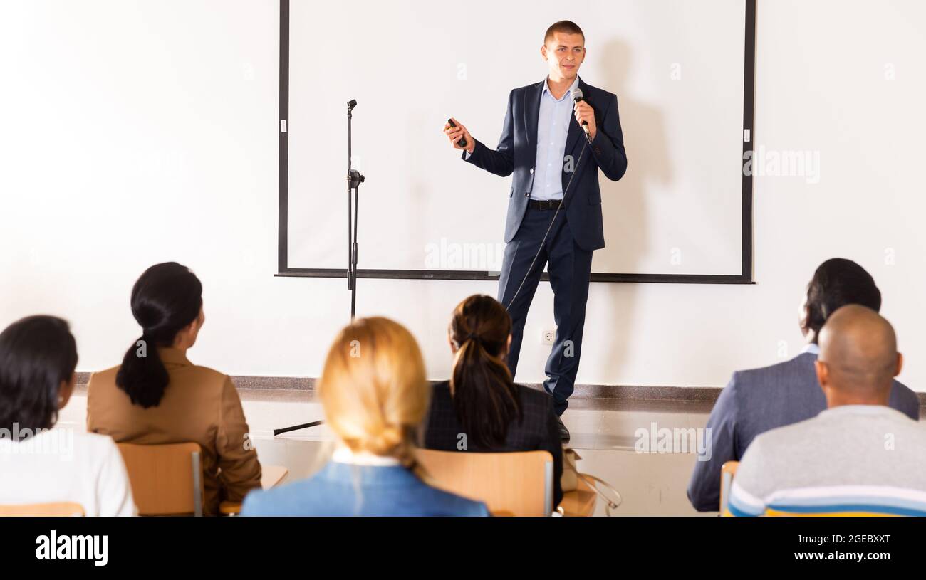 Male coach giving speech at conference hall Stock Photo - Alamy
