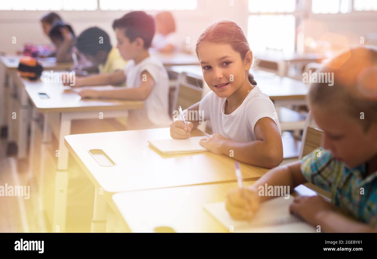 Tween schoolgirl looking at camera with smile in classroom Stock Photo ...