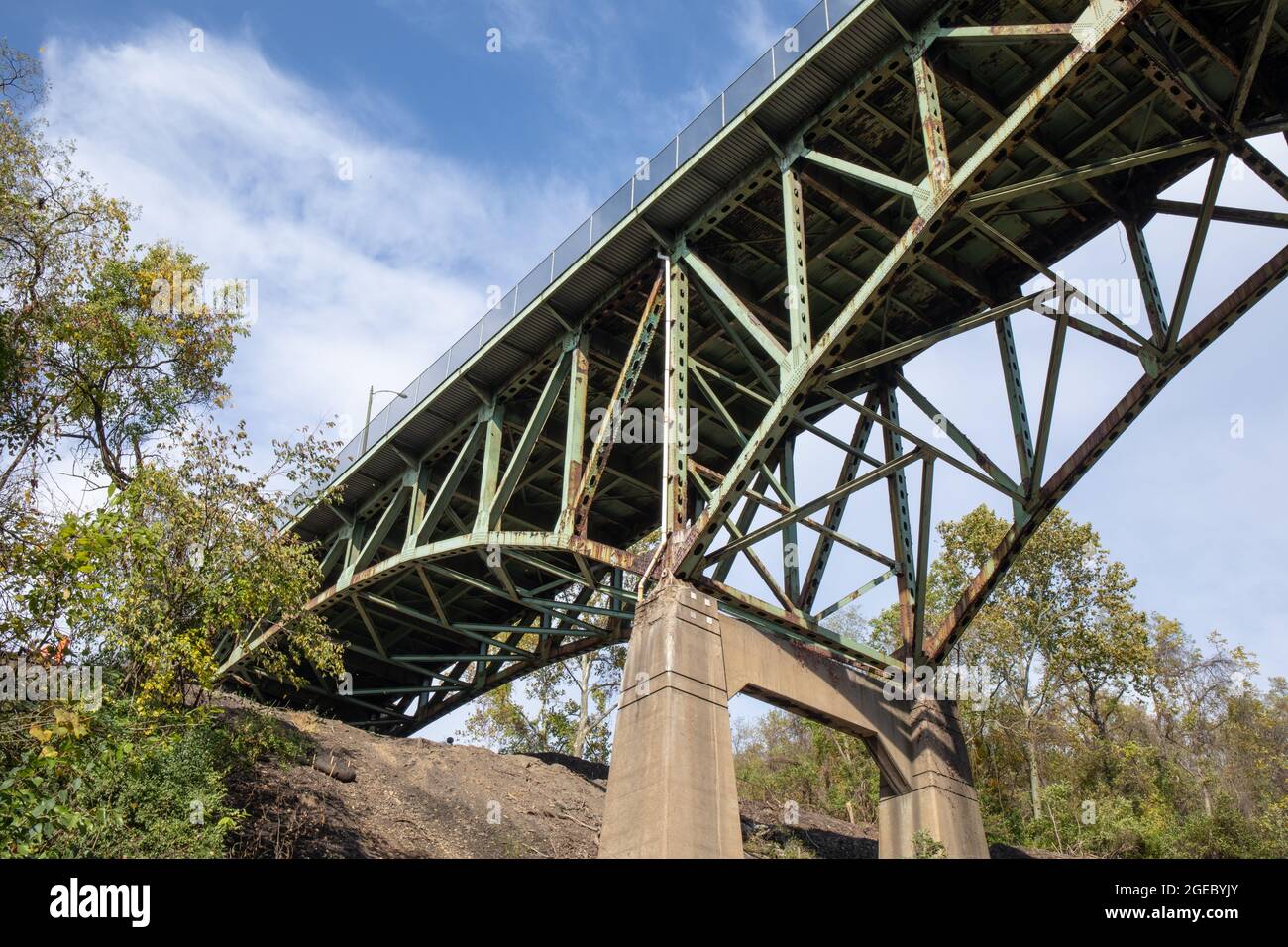 View looking up at an old bridge showing structural deficiencies ...