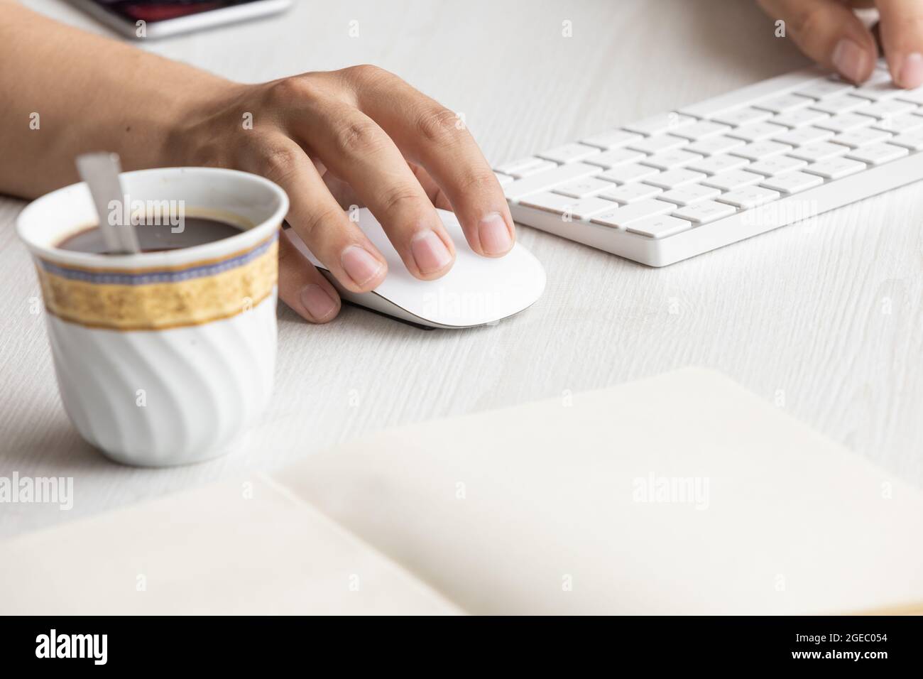 studio with the details of a desk with the hands of a person typing on ...