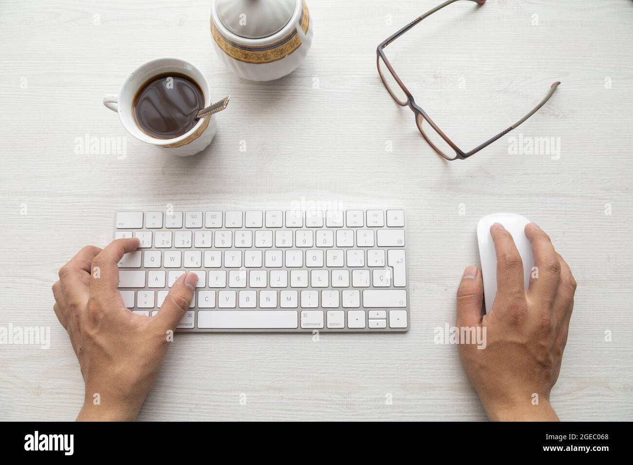 hands of a person typing on a modern keyboard and using a mouse, around ...