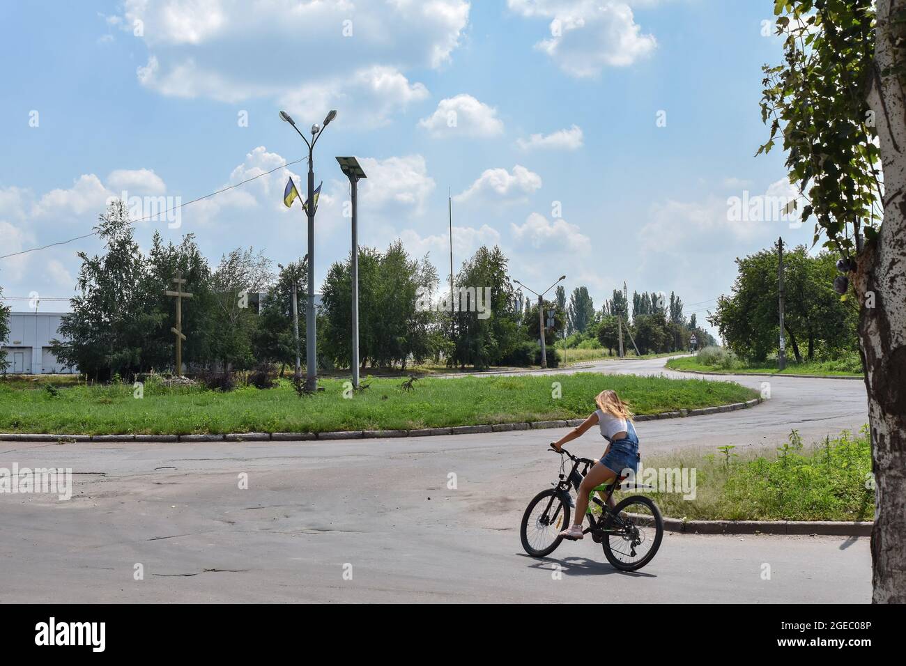 A young girl seen riding a bicycle on the road towards the outskirts of ...