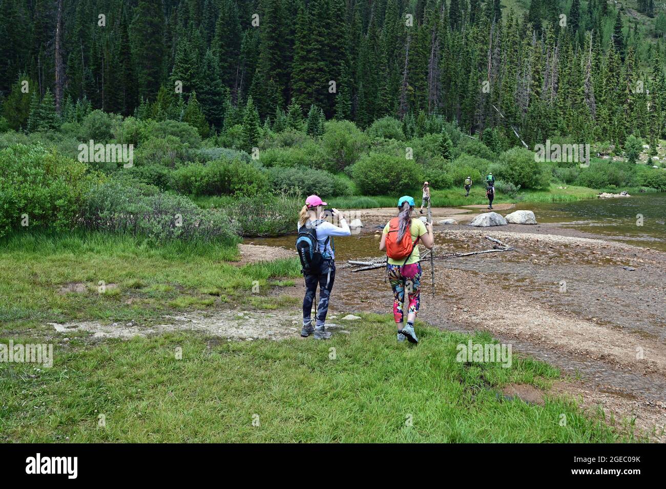 Hikers cross shallow water of Upper Urad Reservoir on Hassell Lake ...