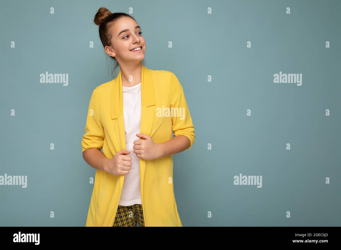 Photo shot of pretty positive happy smiling brunette little girl wearing trendy yellow jacket ...