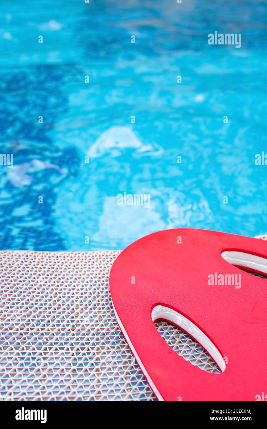 angle view red floating pad near a swimming pool vertical composition ...