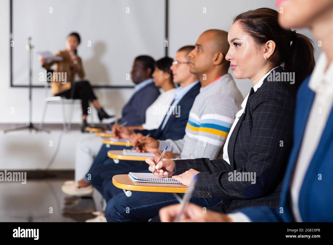 Focused woman listening to lecture at conference Stock Photo - Alamy