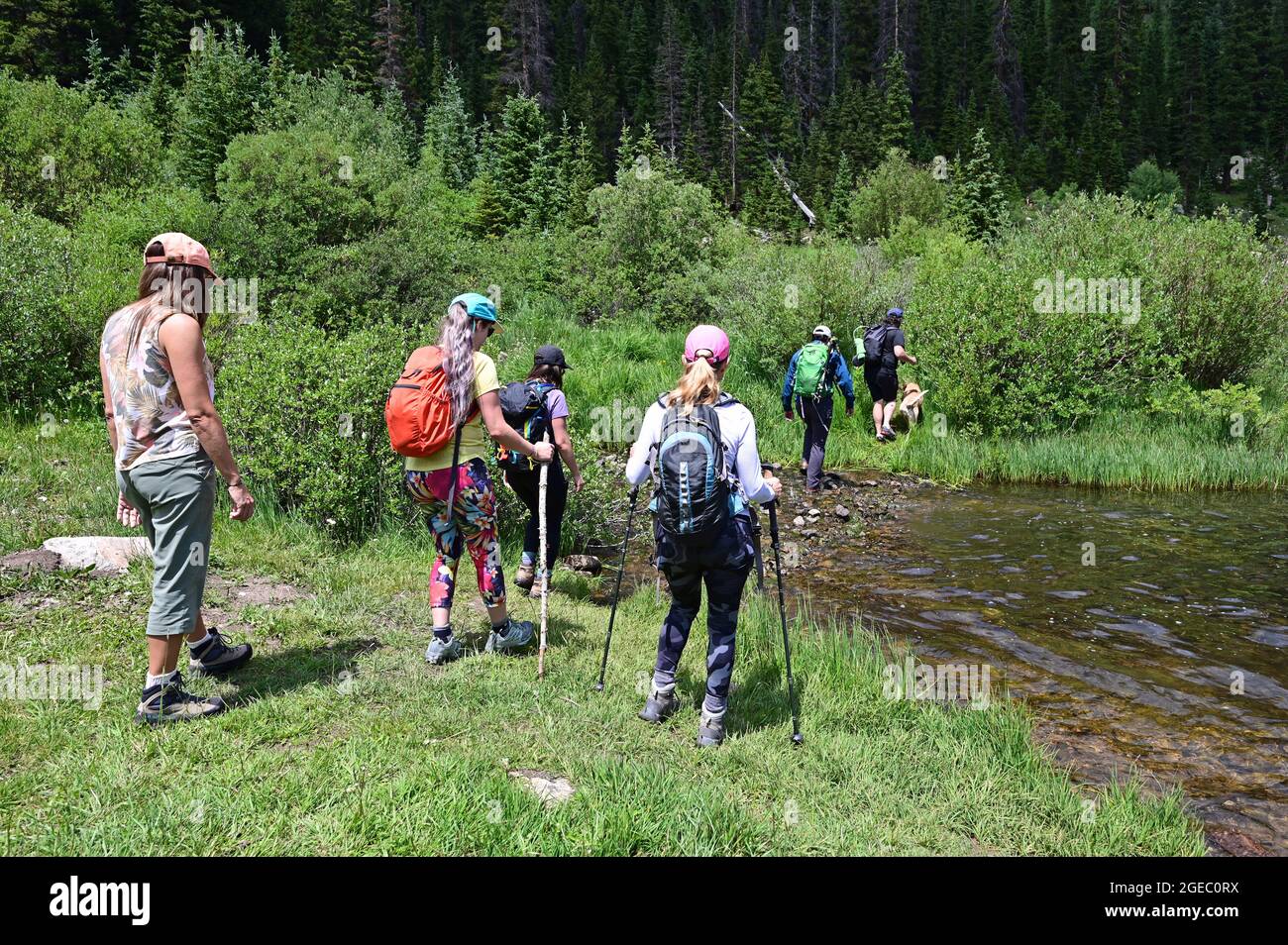 Hikers cross shallow water of Upper Urad Reservoir on Hassell Lake ...