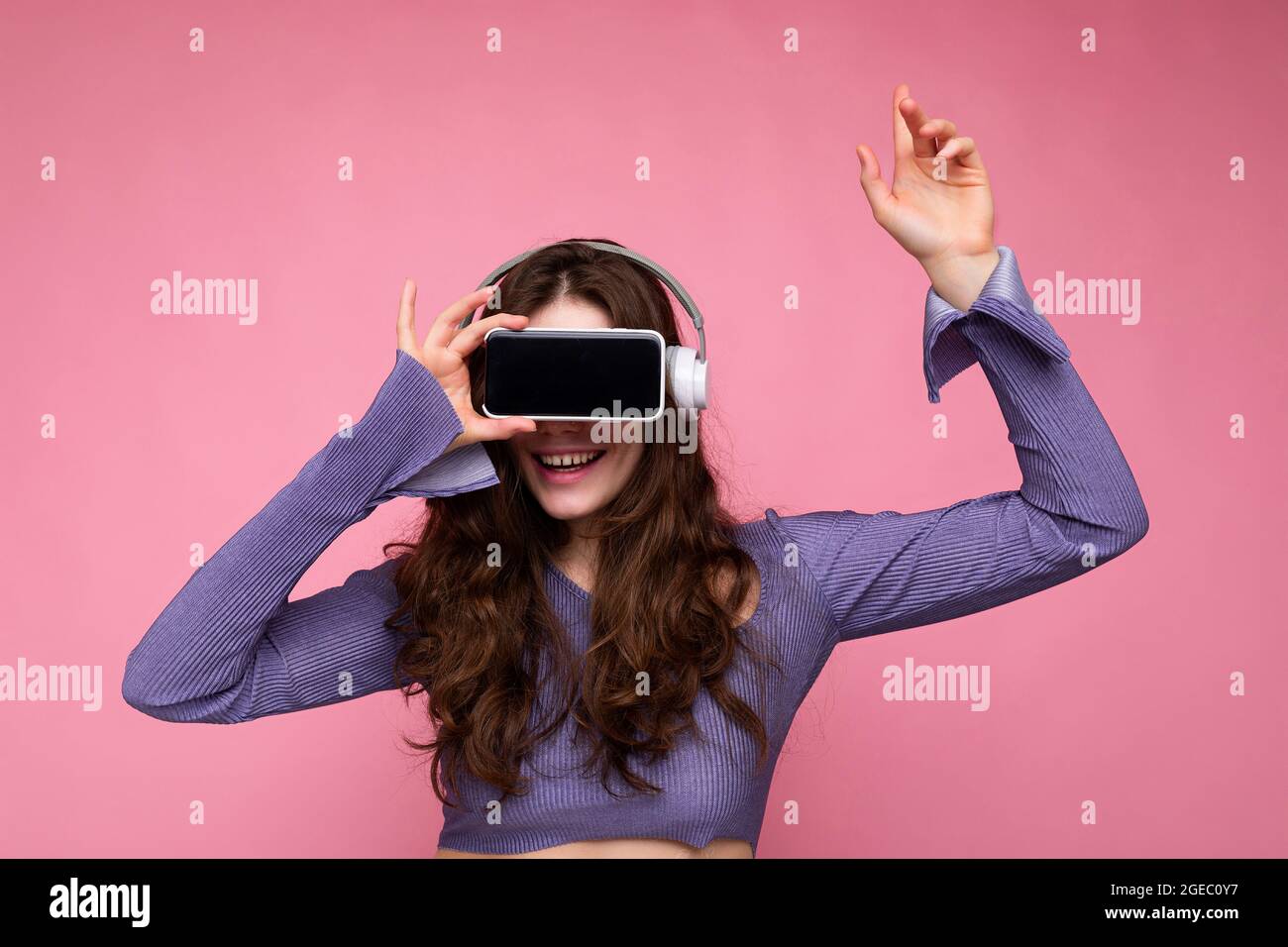 Photo of beautiful happy young brunette curly woman wearing purple crop ...
