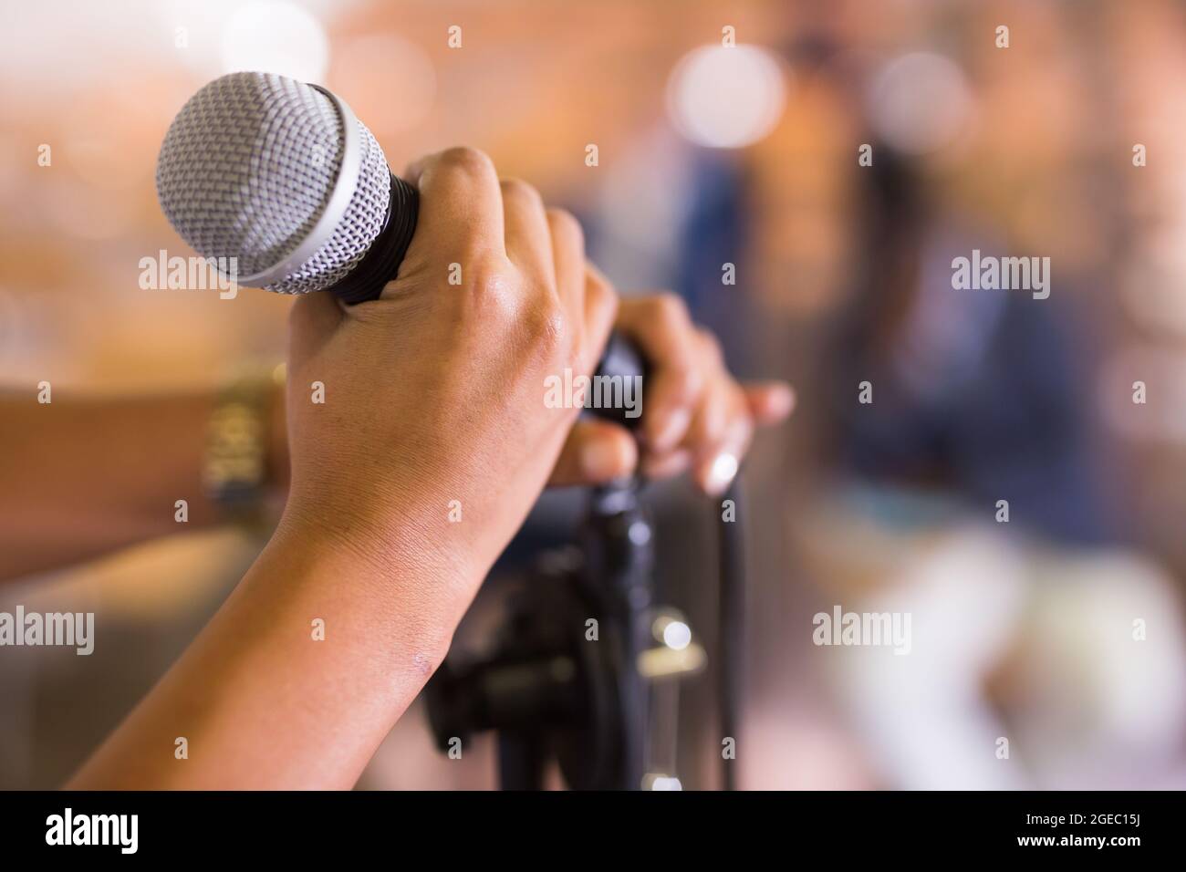 Closeup of female hands holding microphone on blurred background Stock ...