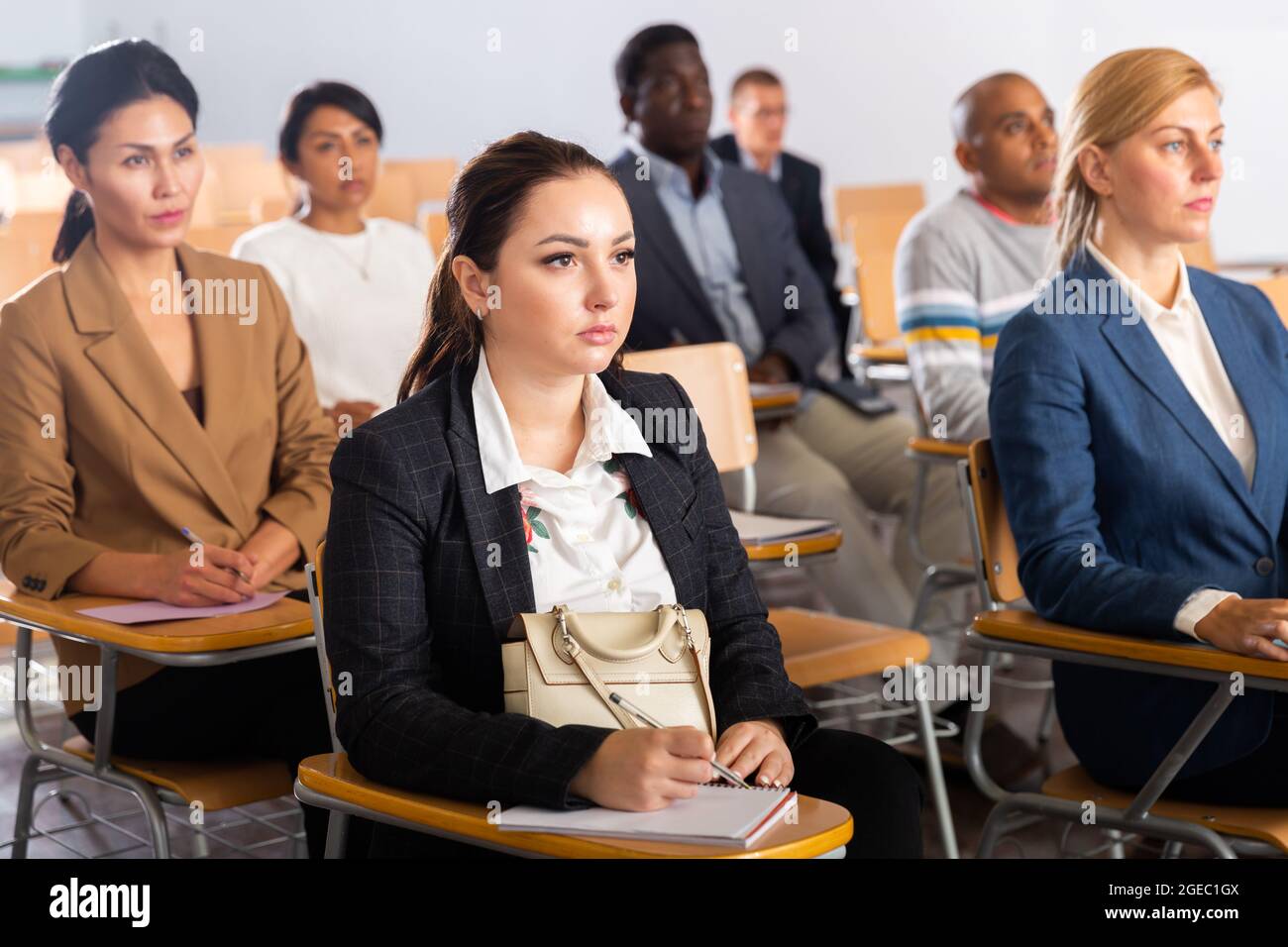 Focused woman listening to lecture at conference Stock Photo - Alamy