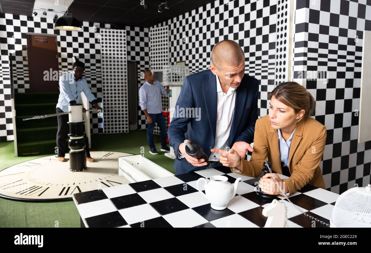 Colleagues playing in chess quest room during team building Stock Photo ...