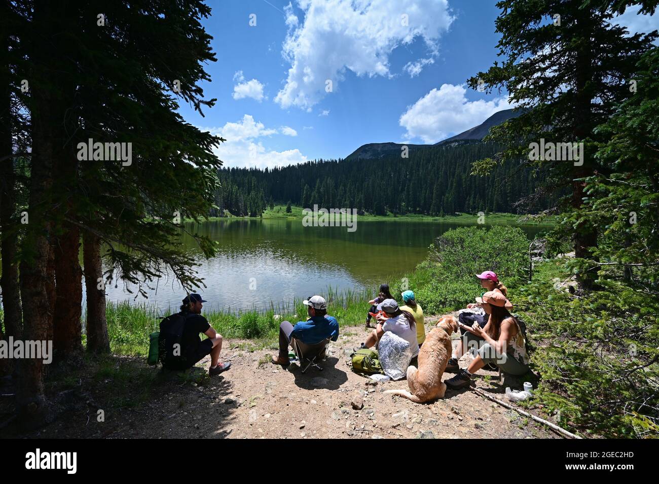 Hikers enjoy view of Hassell Lake in Arapaho National Forest, Colorado ...