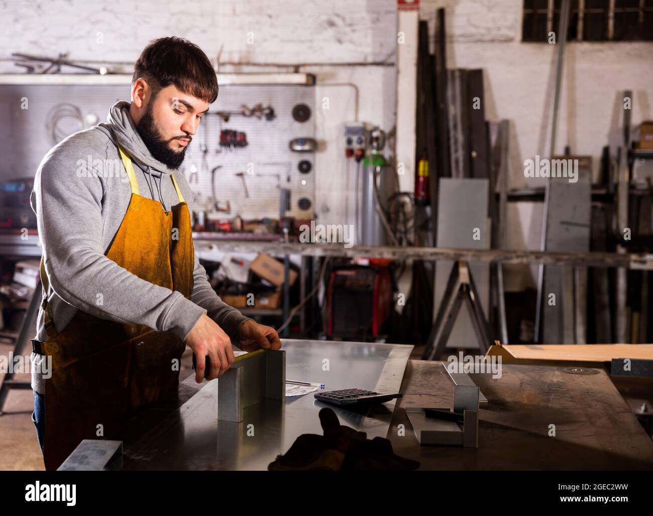 Foreman measures part and takes notes on paper Stock Photo - Alamy
