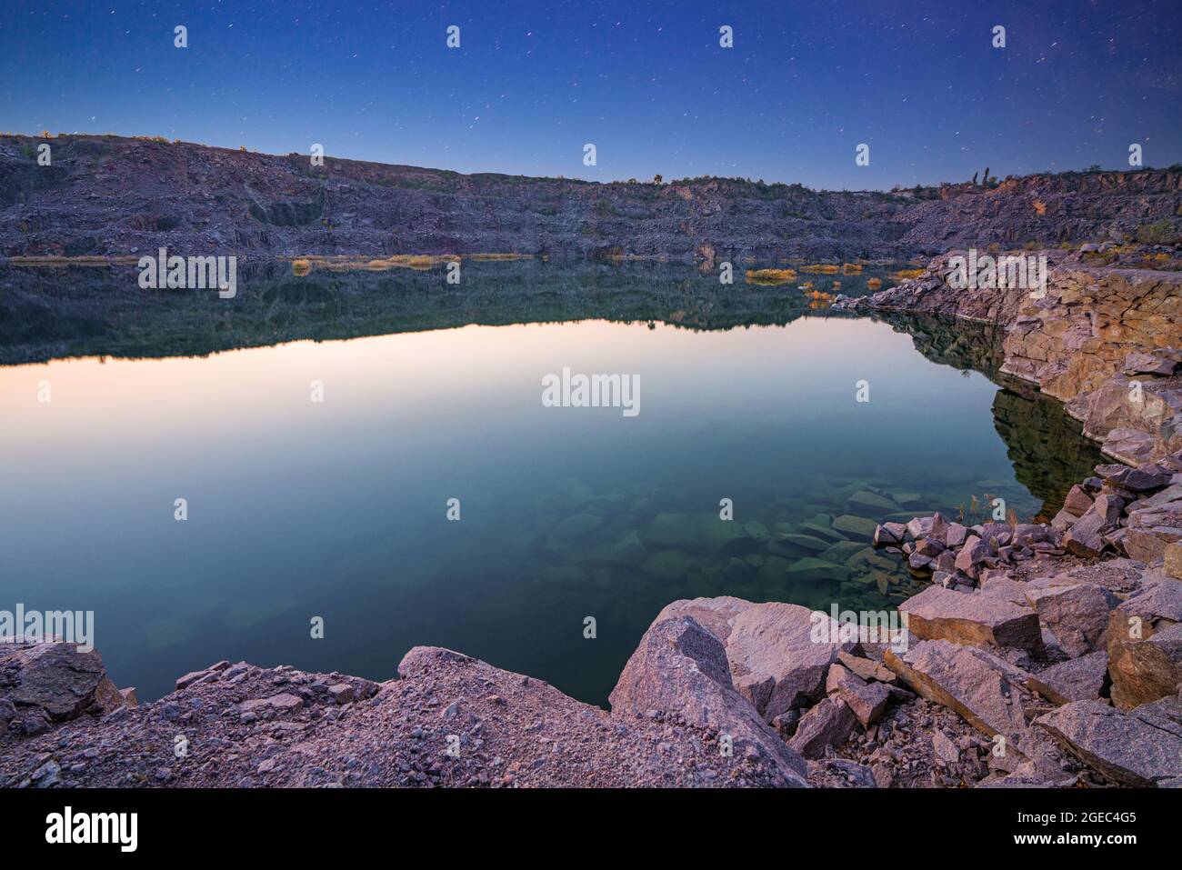 Small lake surrounded by stone waste from mine work Stock Photo - Alamy