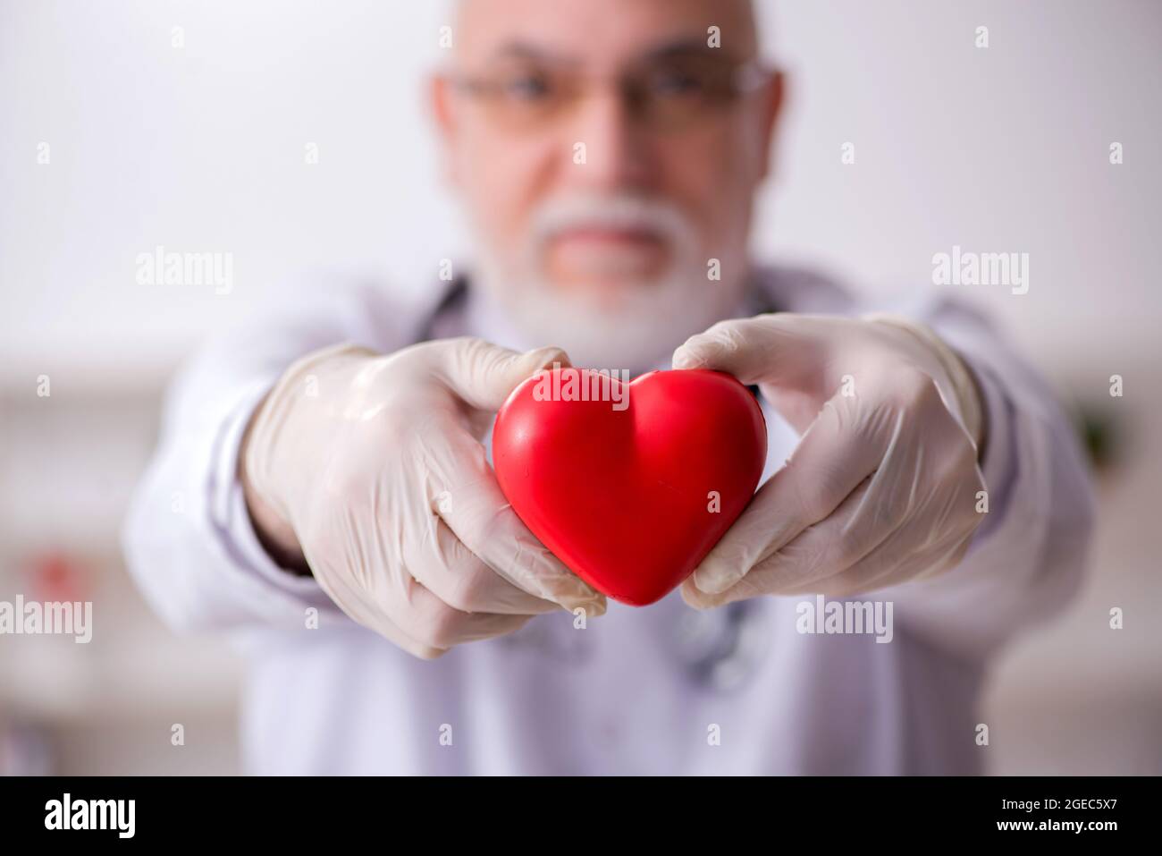 Old doctor cardiologist working in the clinic Stock Photo - Alamy