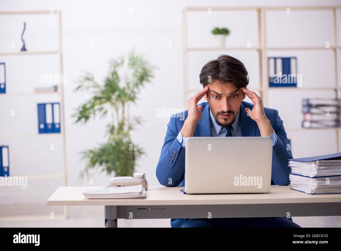 Young employee and too much work in the office Stock Photo - Alamy