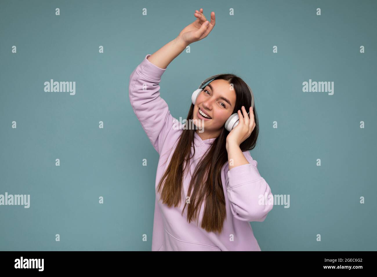 Attractive positive smiling young brunette woman wearing light purple ...