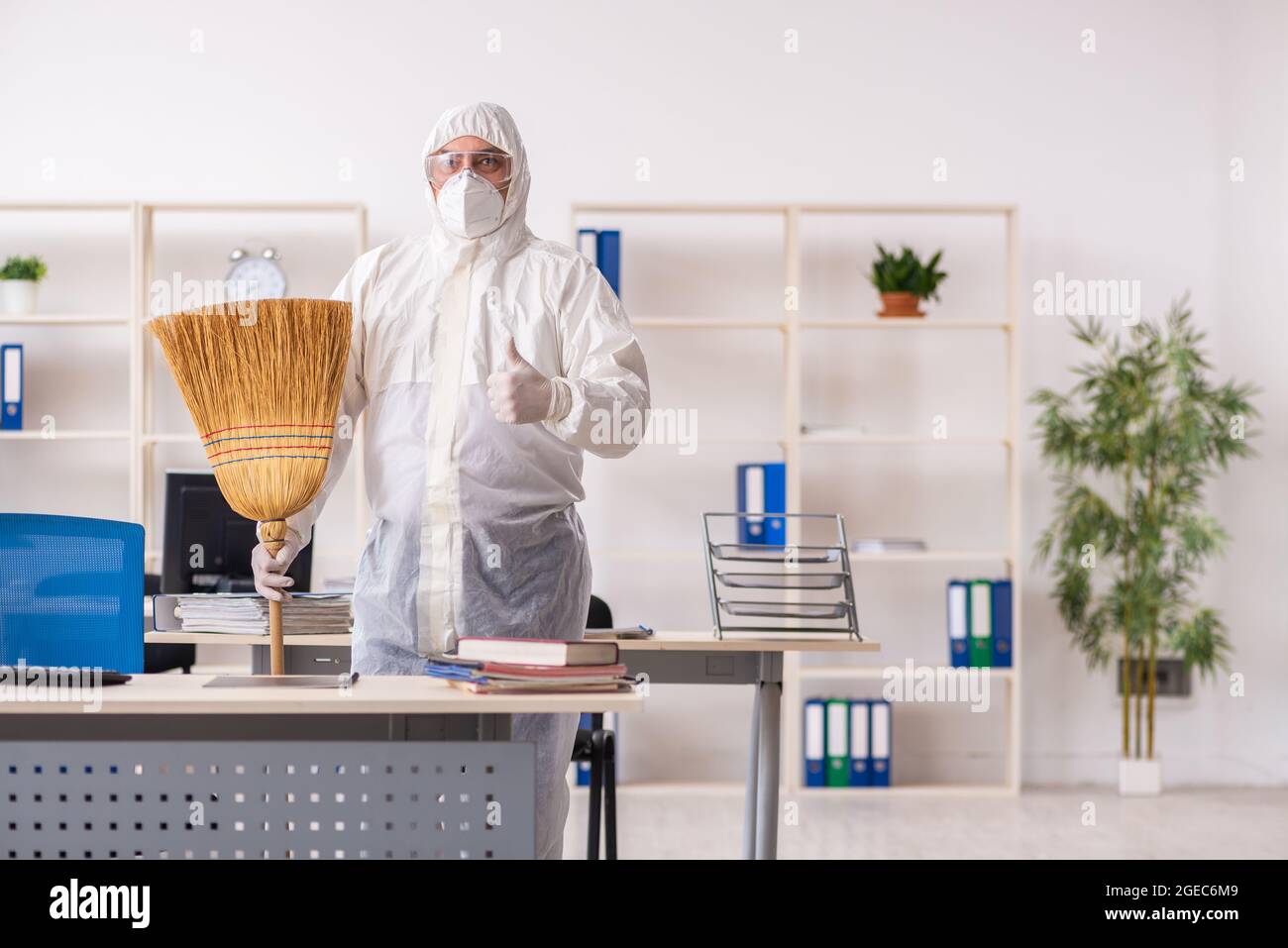 Old contractor cleaning the office holding broom Stock Photo - Alamy