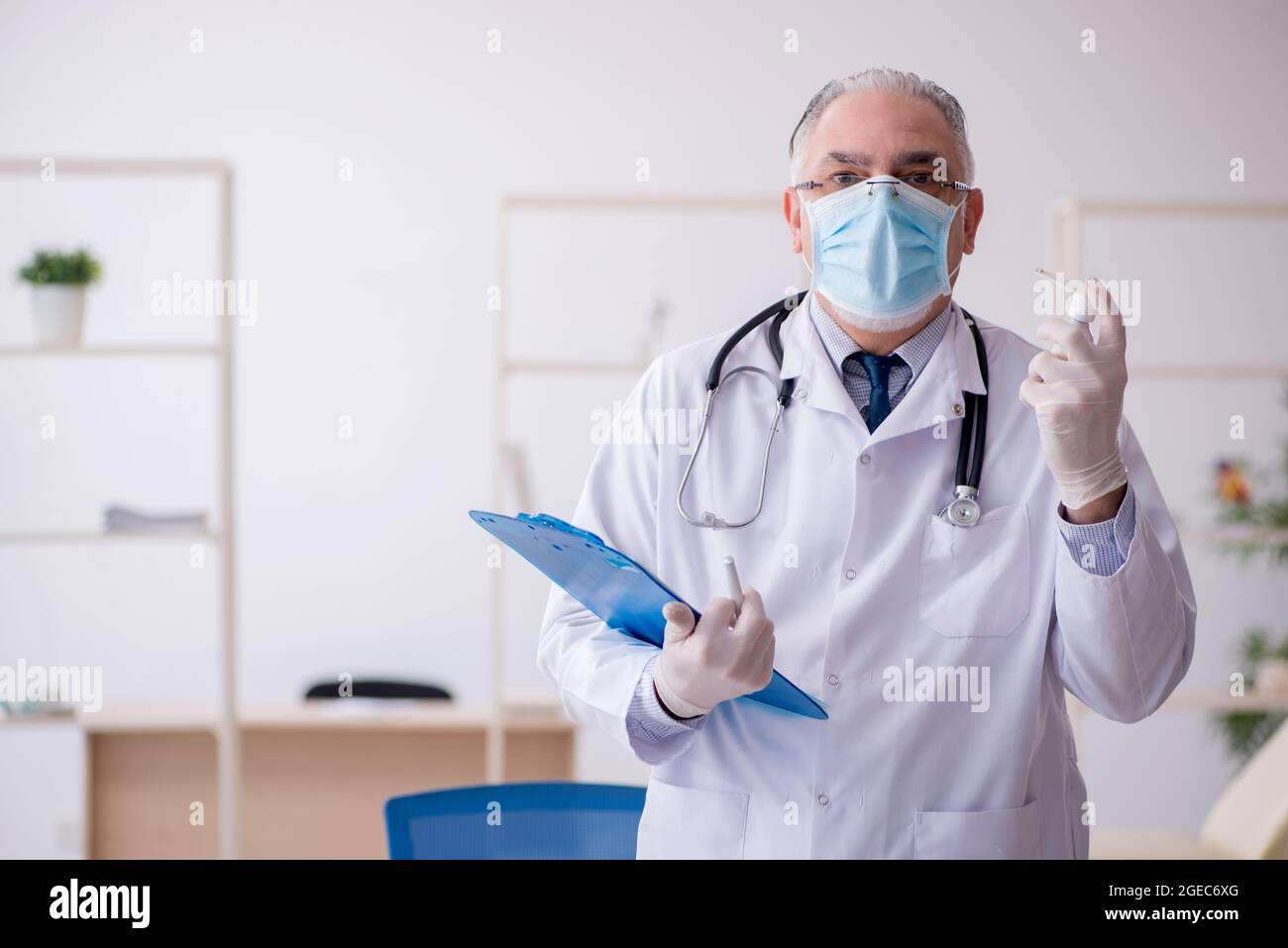 Old doctor working in the clinic Stock Photo - Alamy
