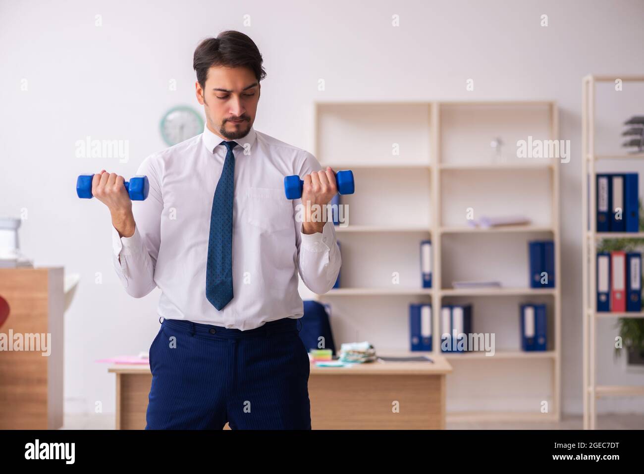 Young businessman employee doing sport exercises during break Stock ...