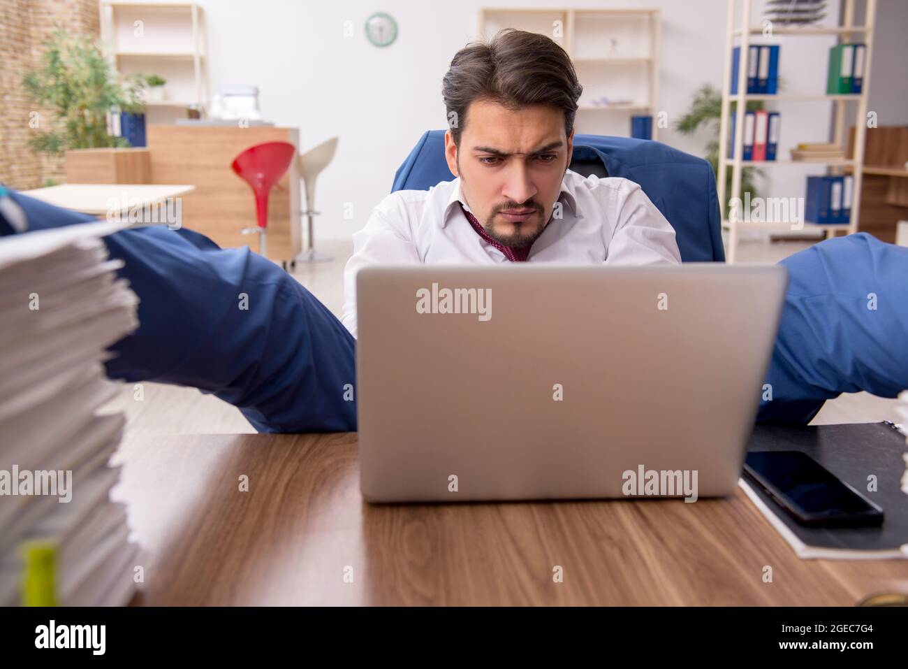 Young businessman employee and too much work in the office Stock Photo ...
