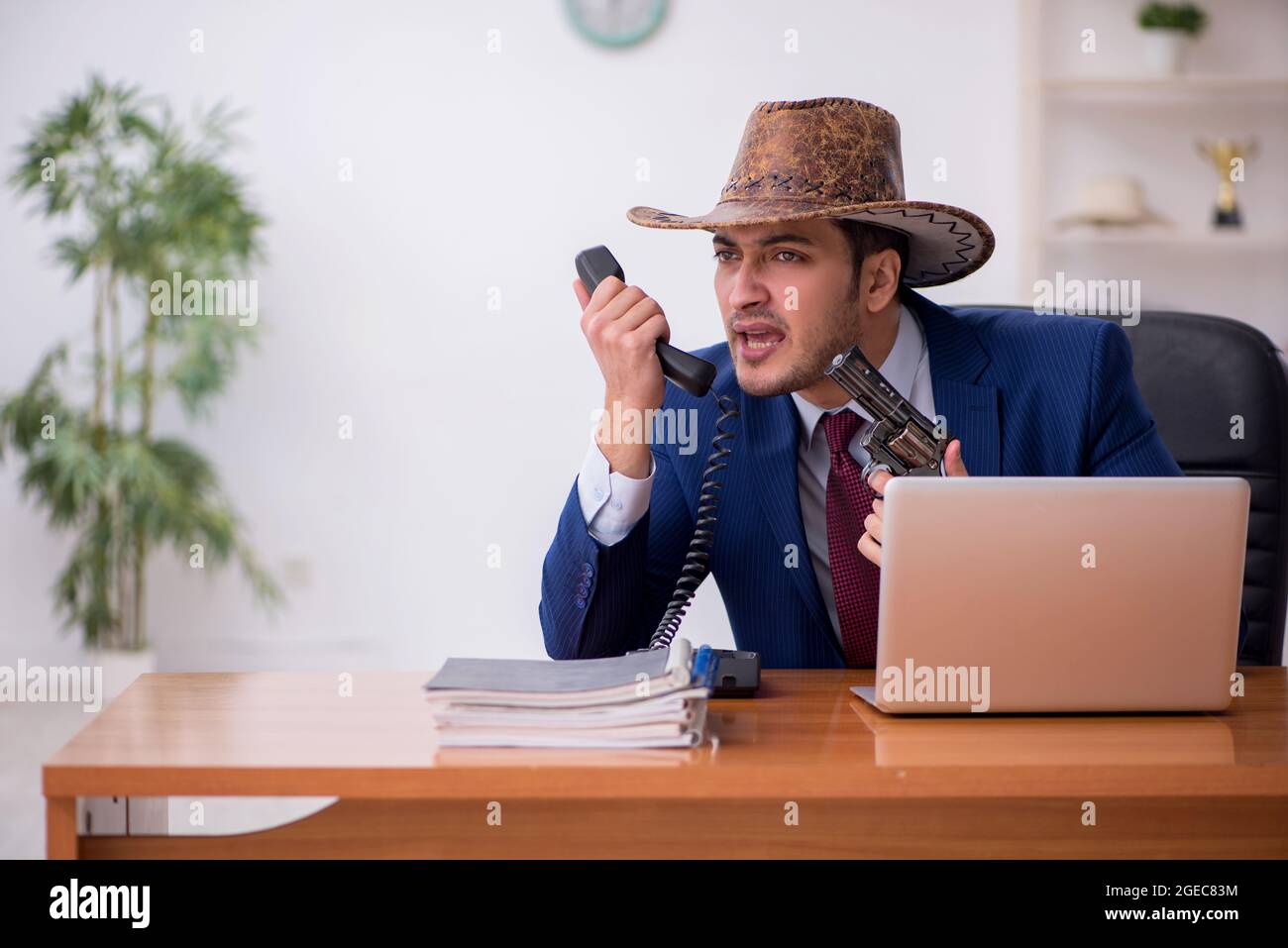 Young cowboy employee working at workplace Stock Photo - Alamy