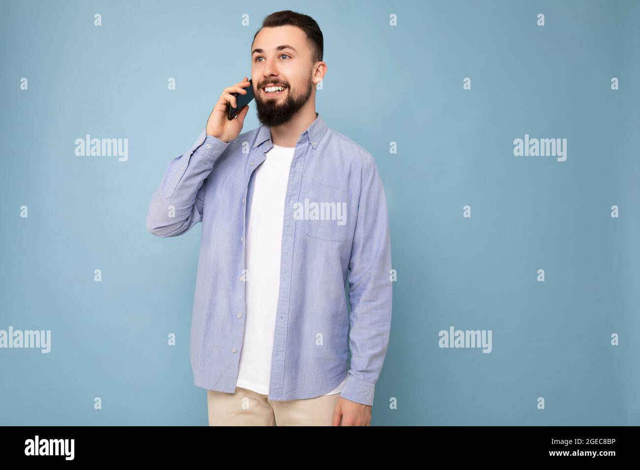 Photo shot of happy good looking young brunet bearded man wearing ...