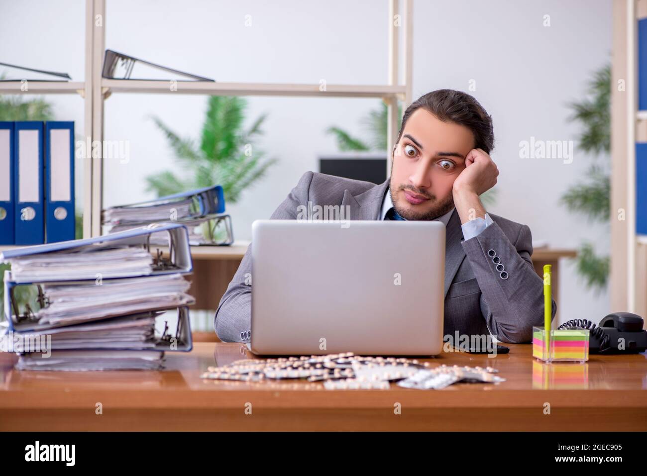 Male sick employee suffering at workplace Stock Photo - Alamy