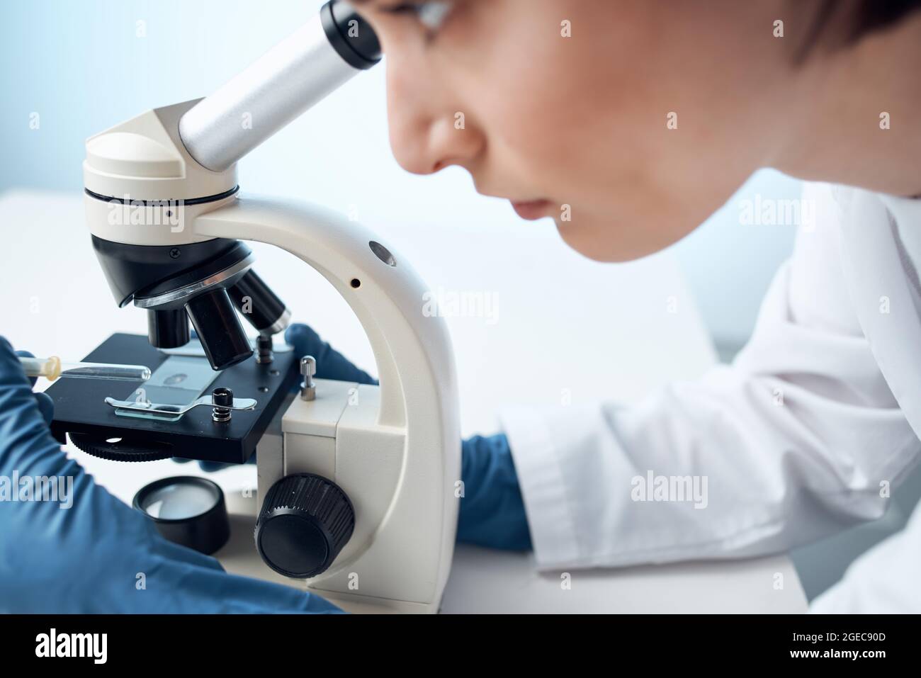 female laboratory assistant looking microscope diagnostics professional ...