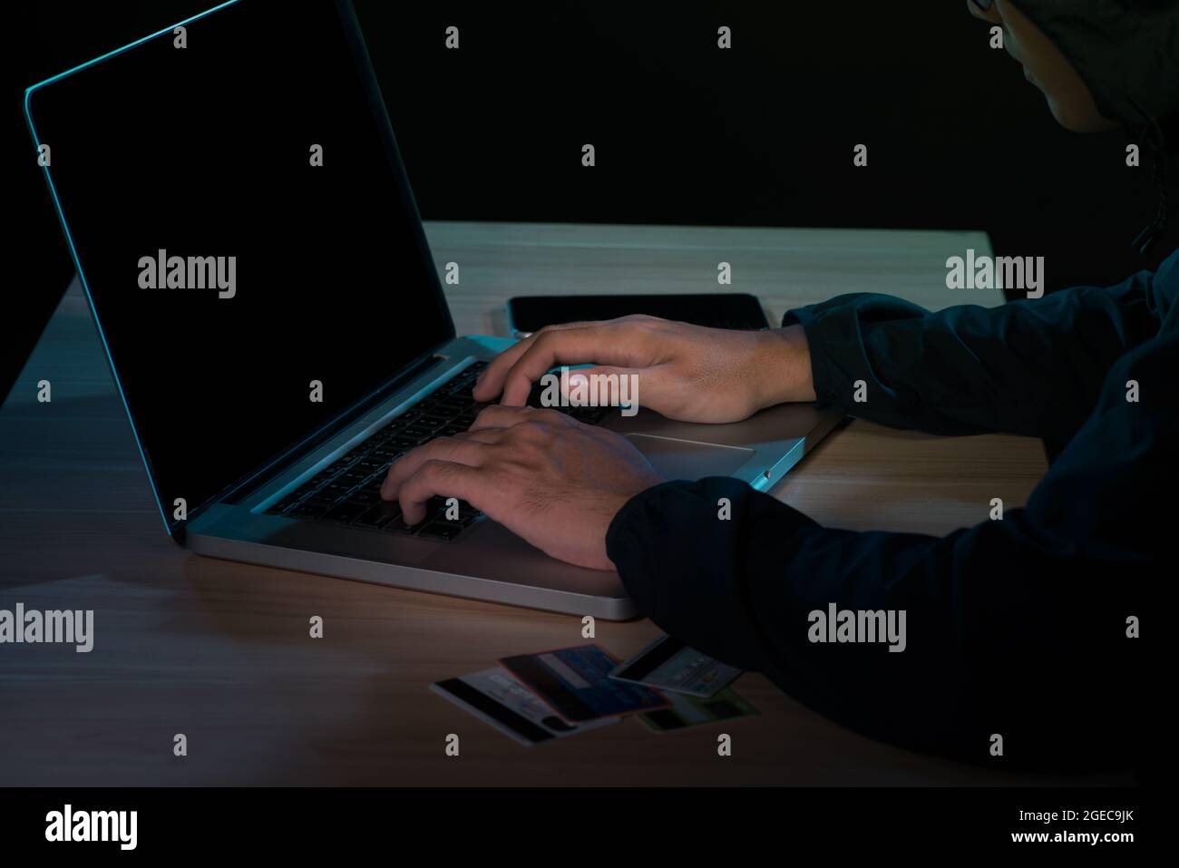 Man working on laptop in dark room Stock Photo - Alamy