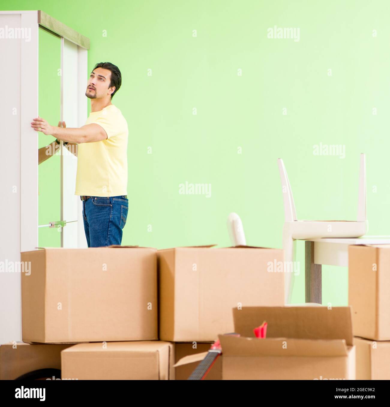 The young handsome man moving in to new house with boxes Stock Photo ...