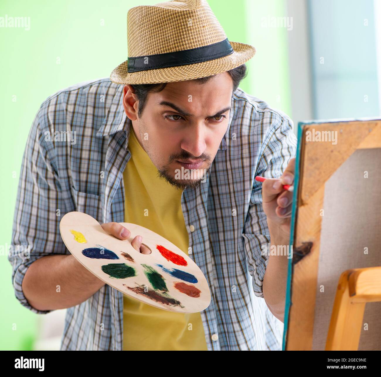 The young male artist working on new painting in his studio Stock Photo - Alamy