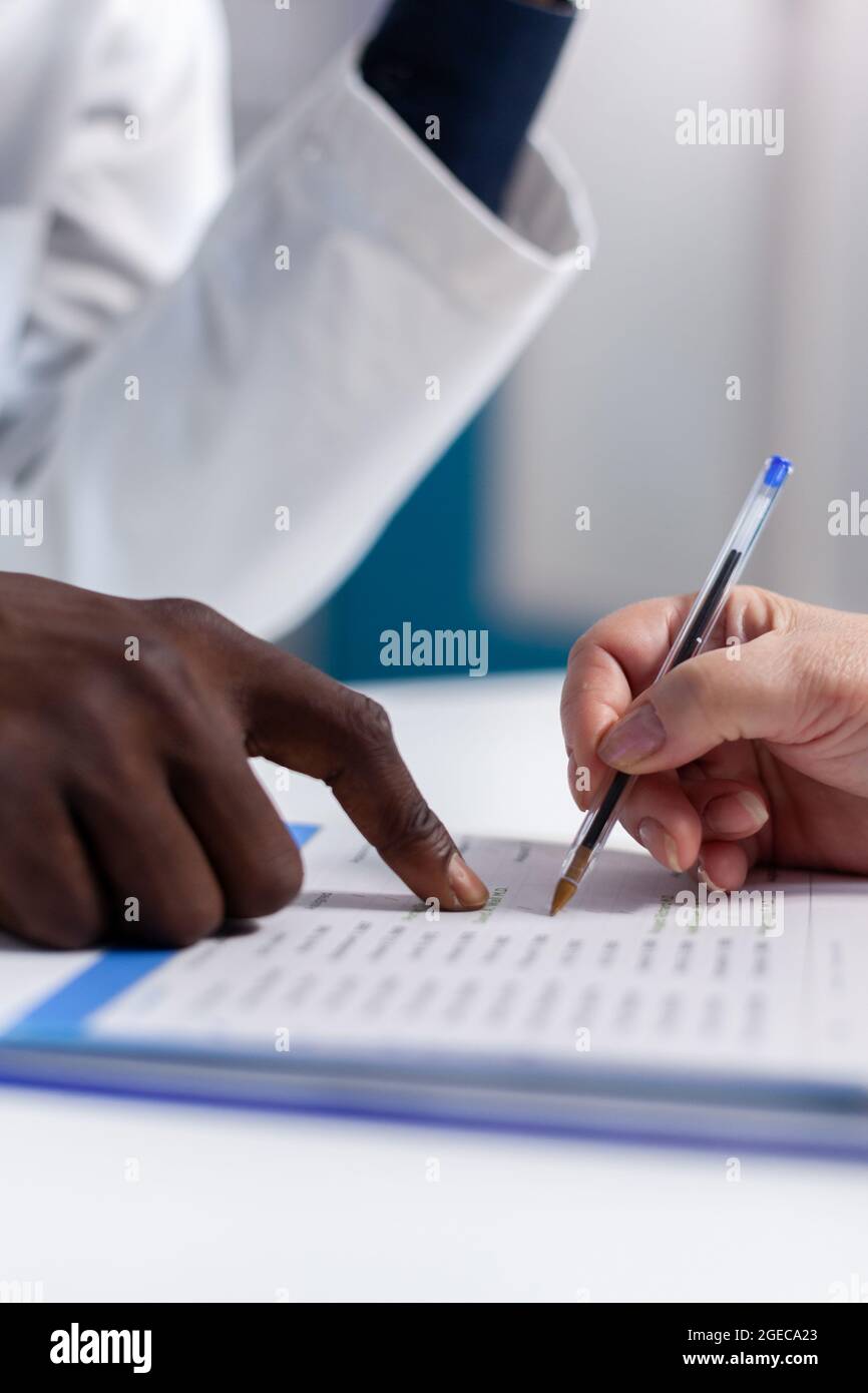 Close up of hands on desk at healthcare clinic. Caucasian patient ...
