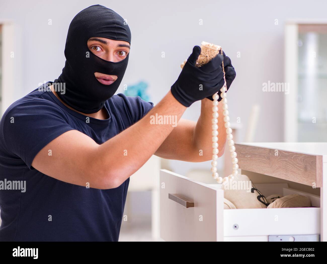 The robber wearing balaclava stealing valuable things Stock Photo - Alamy