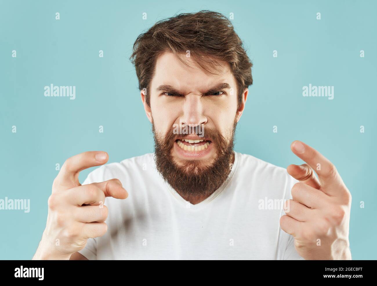 emotional man in a white t-shirt irritated facial expression blue ...