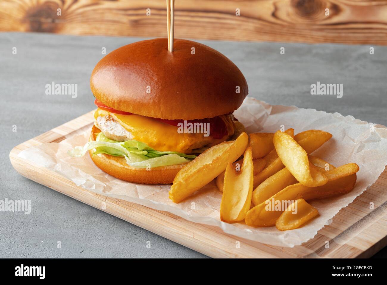 Fresh burger and potato wedges on gray wooden background Stock Photo ...